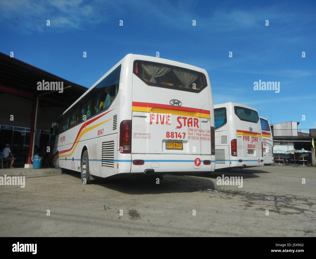 This photograph shows Five Star and Cisco buses waiting at a bus stop ...