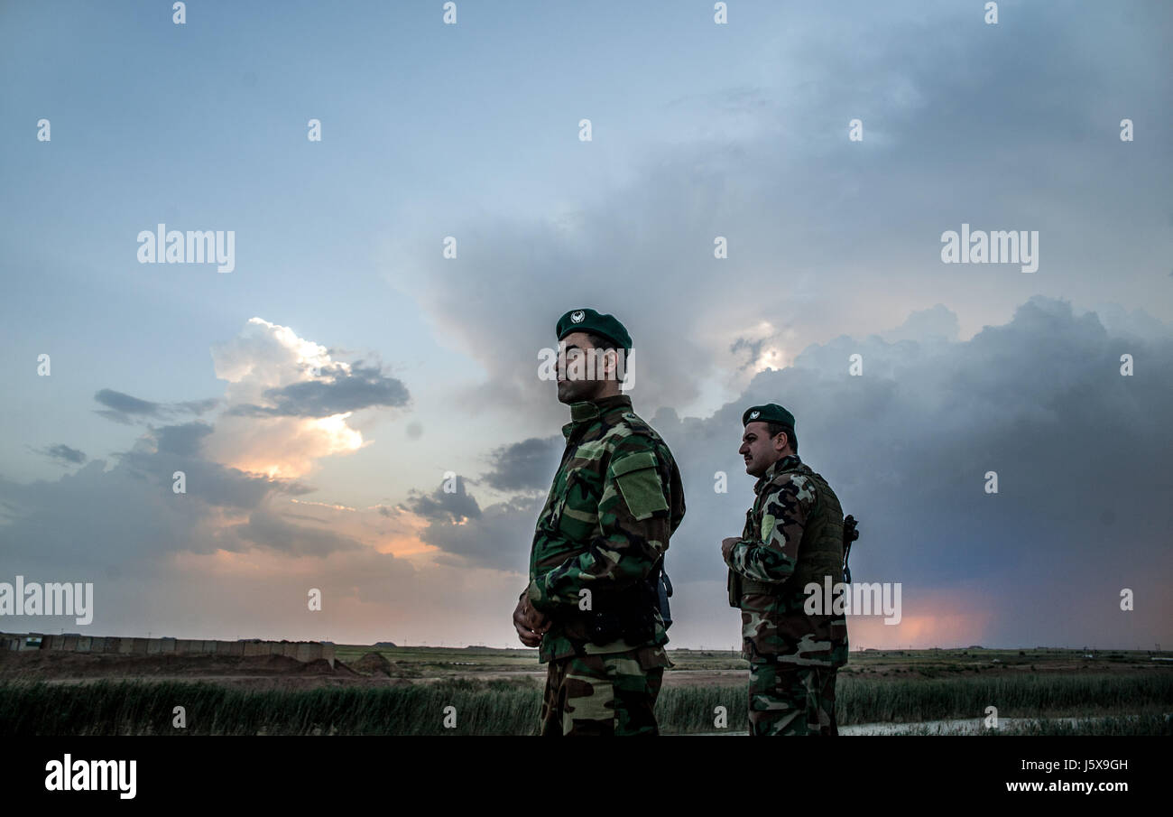 Kurdish Peshmerga forces stand guard at a checkpoint near the frontline ...