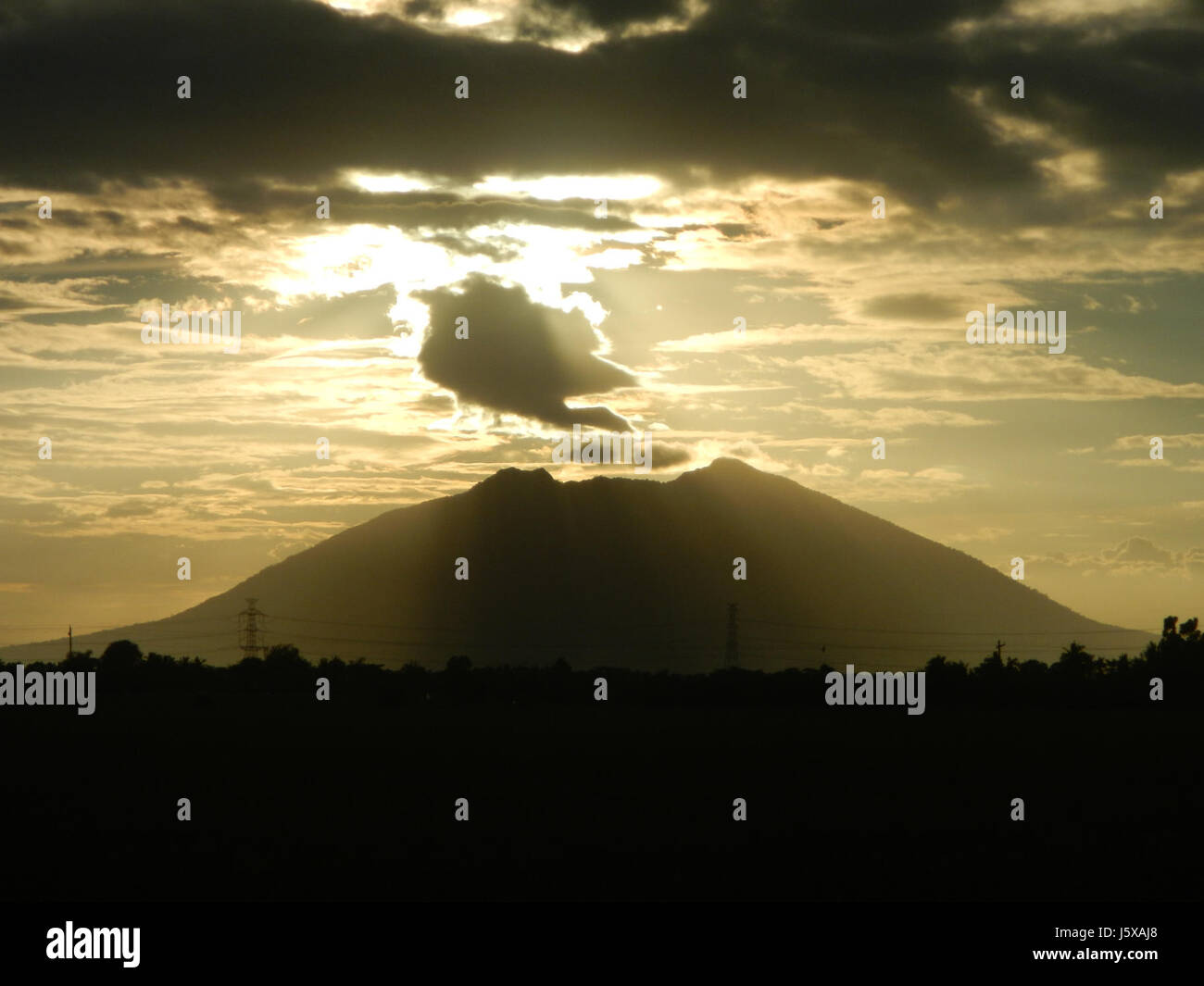 This image captures a dramatic sunset over Mount Arayat in San Isidro ...