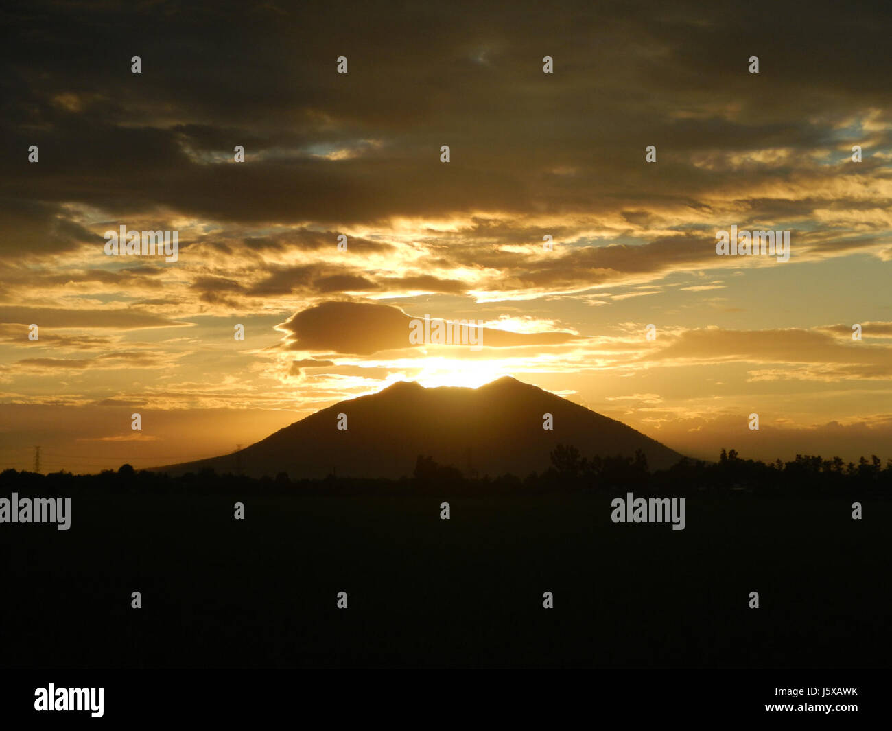 This photograph captures the stunning sunset view over Mount Arayat ...