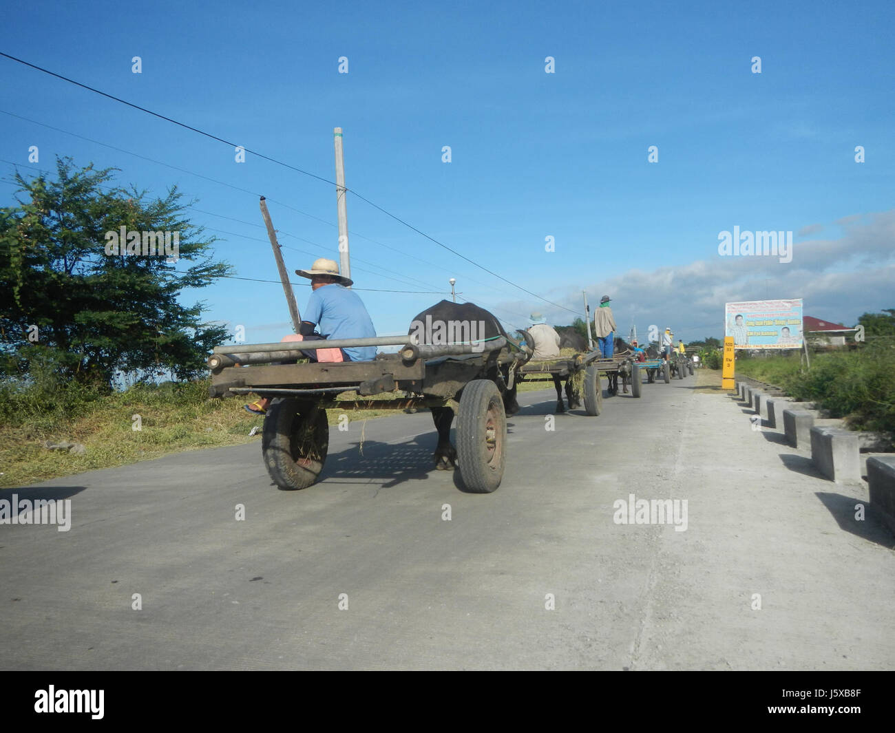 This image captures a traditional Filipino caravan, with wooden carts ...