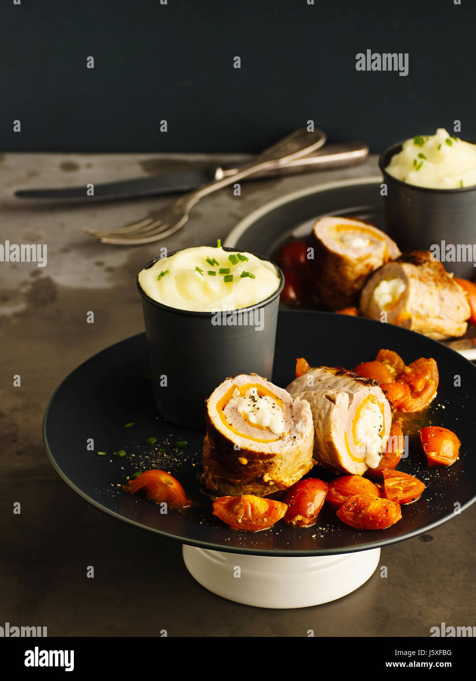 Filled cutlet rolls with mashed potatoes and balsamic tomatoes Stock ...