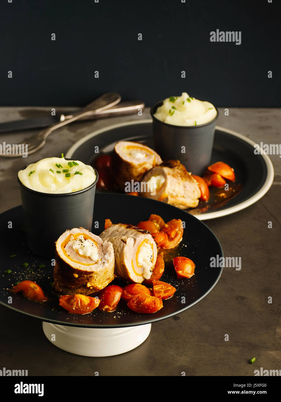 Filled cutlet rolls with mashed potatoes and balsamic tomatoes Stock ...