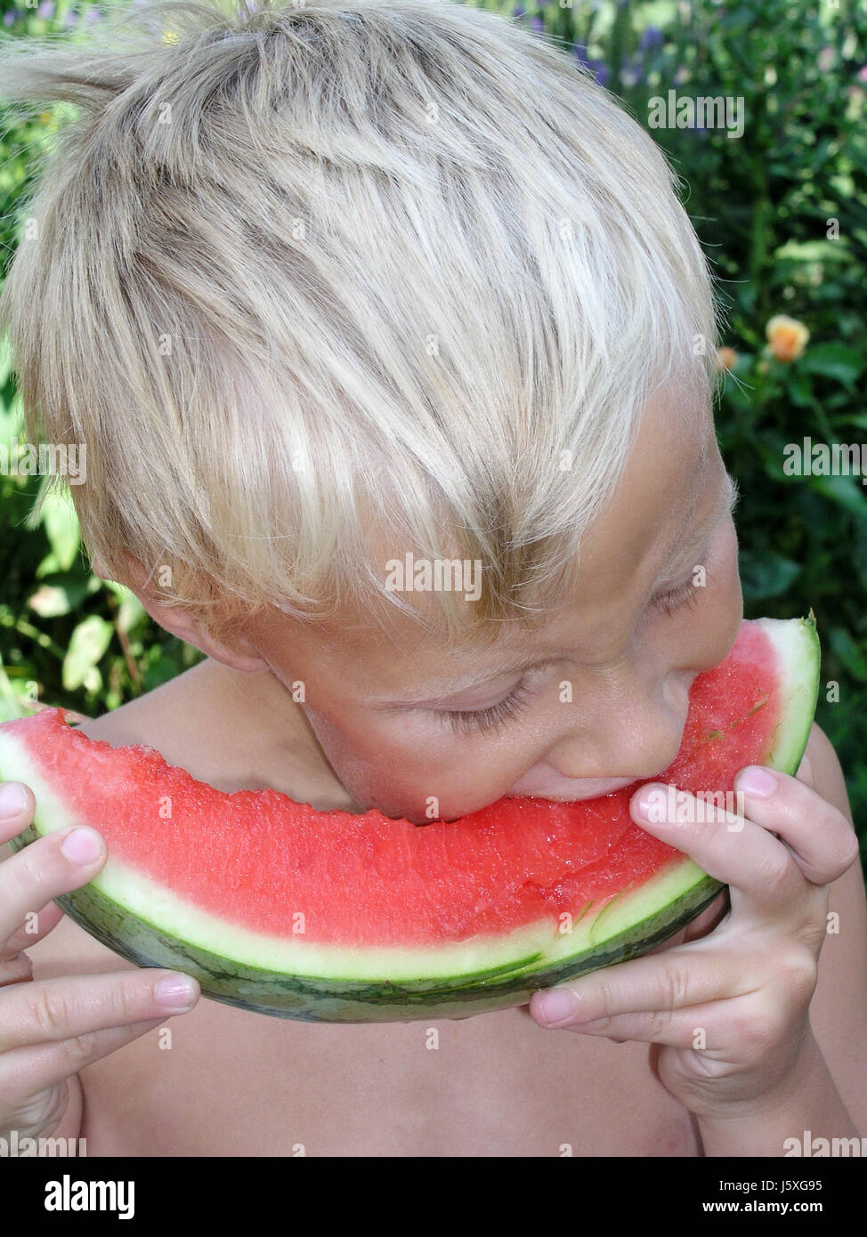 boy biting into a melon Stock Photo - Alamy