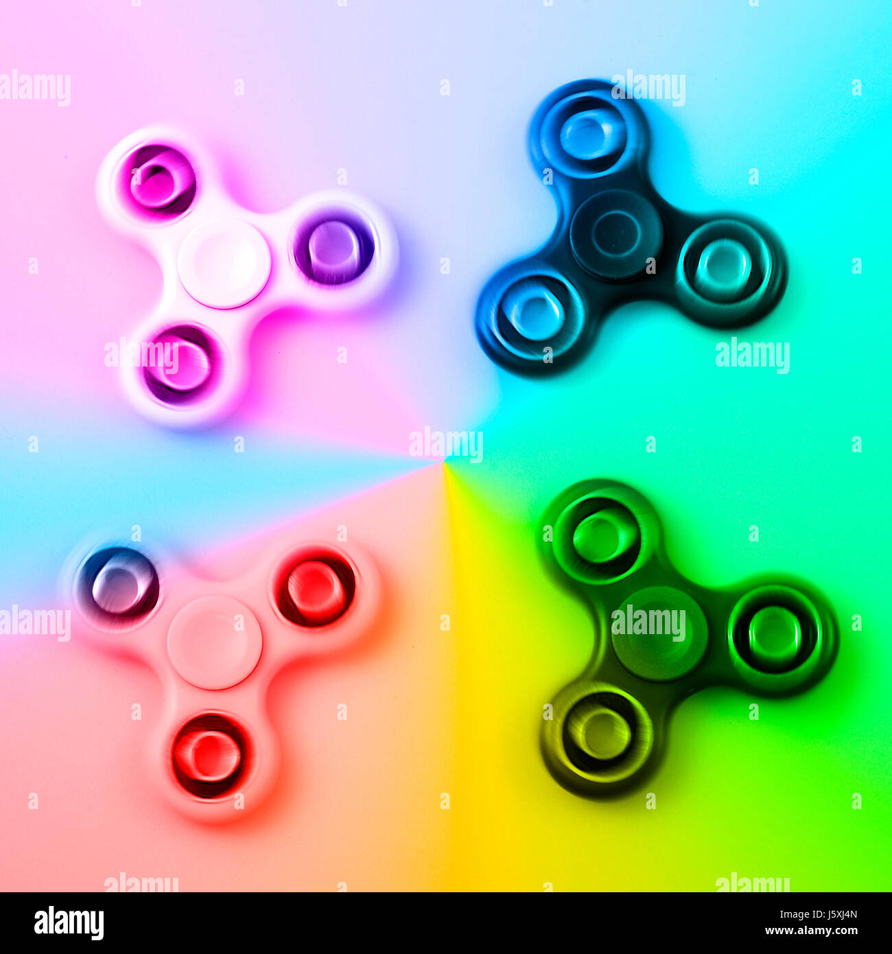 Four colored Hand spinner, fidgeting hand toy rotating Stock Photo - Alamy