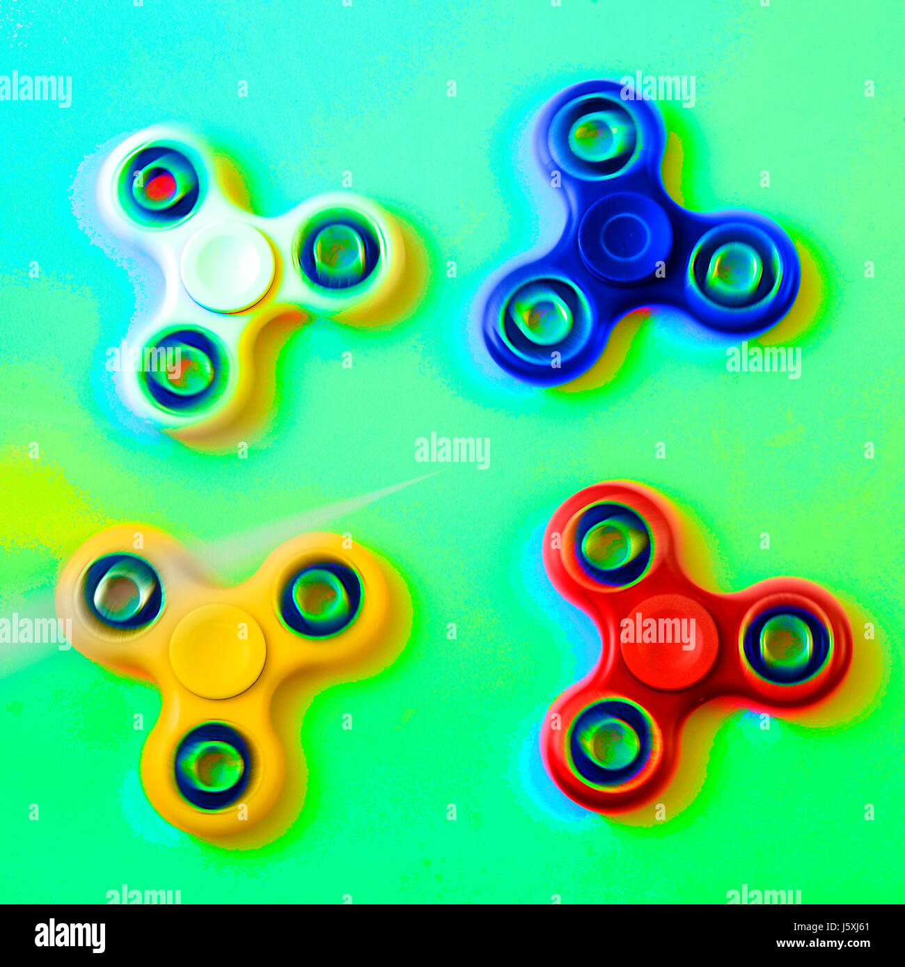 Four colored Hand spinner, fidgeting hand toy rotating Stock Photo - Alamy