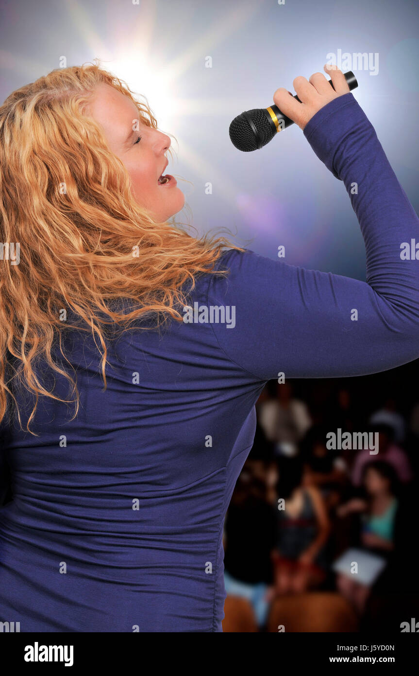 Middle age woman singer performing at a concert Stock Photo - Alamy