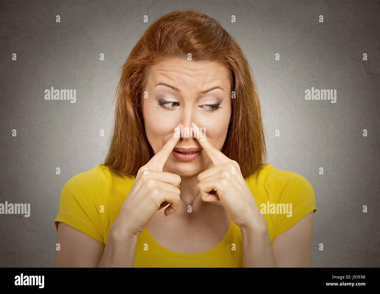 Closeup portrait headshot woman pinches nose with fingers hands looks ...