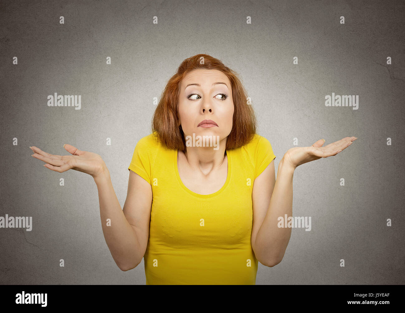 Portrait dumb young woman arms out shrugs shoulders who cares so what I ...