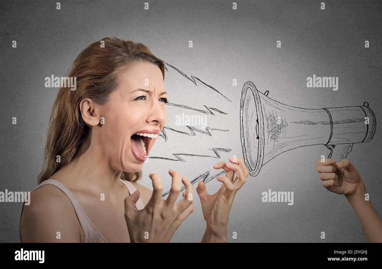 Portrait angry hysterical woman shouting against someones loud ...