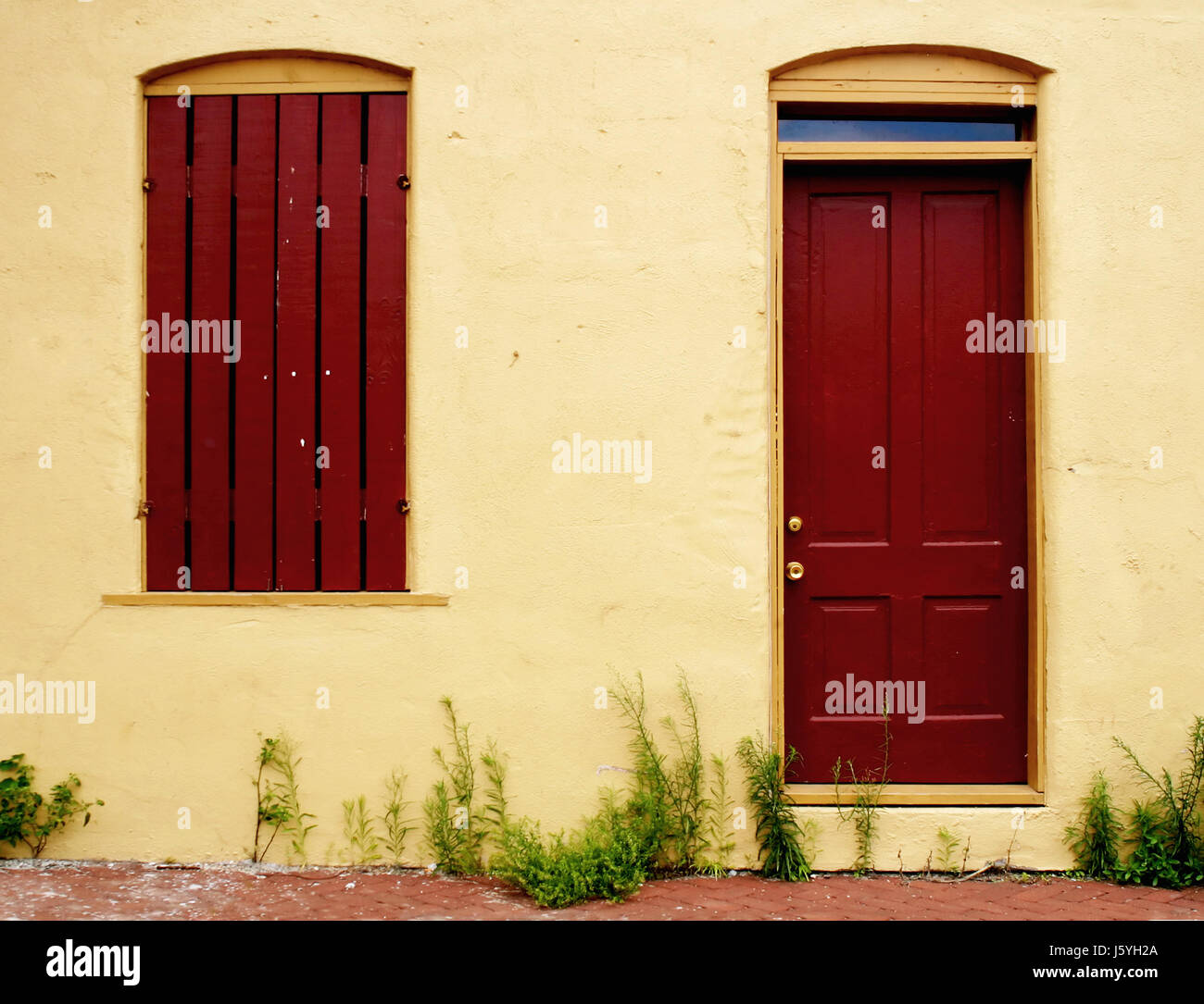 window porthole dormer window pane door sidewalk paint stucco weeds ...