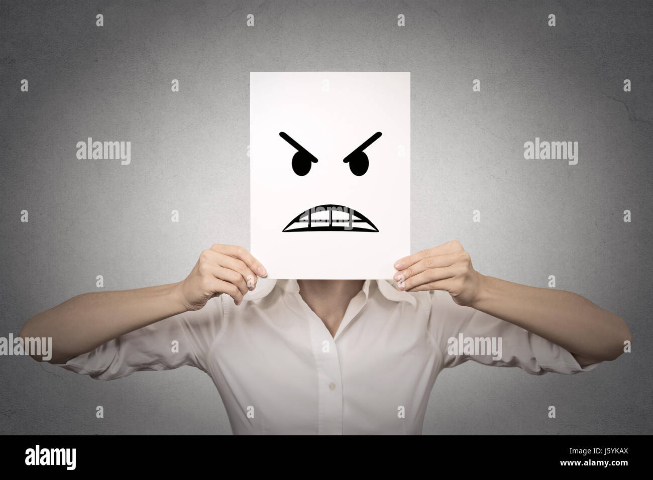 businesswoman covering her face with angry mask isolated grey wall ...