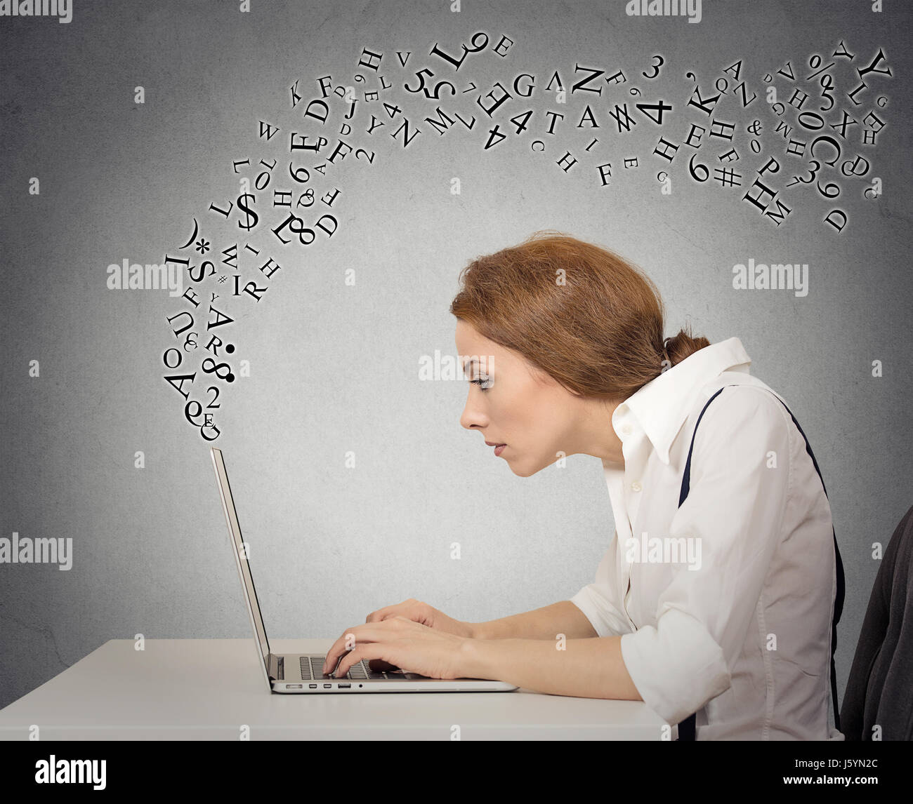 Woman typing on her laptop computer with alphabet letters flying around ...