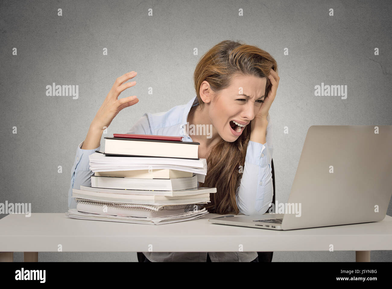 Beautiful girl stressed by studying to hard screaming isolated grey ...