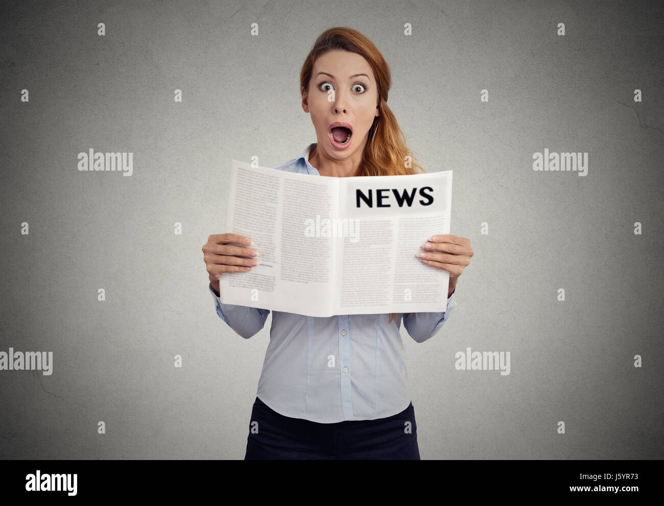 young shocked woman reading magazine Stock Photo - Alamy