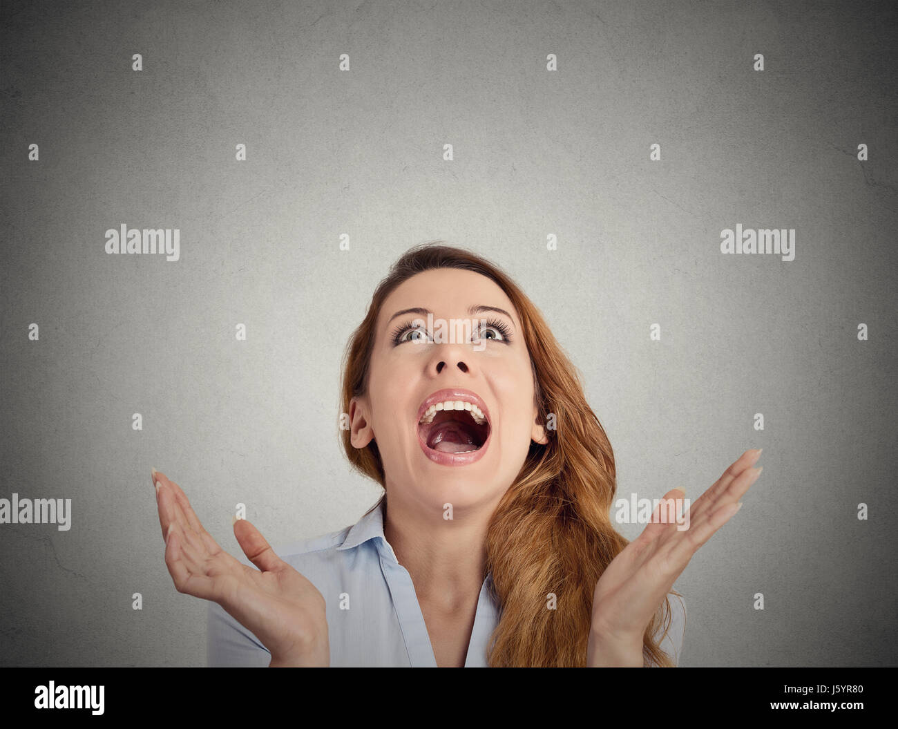 surprised beautiful woman looking up isolated on grey wall background ...