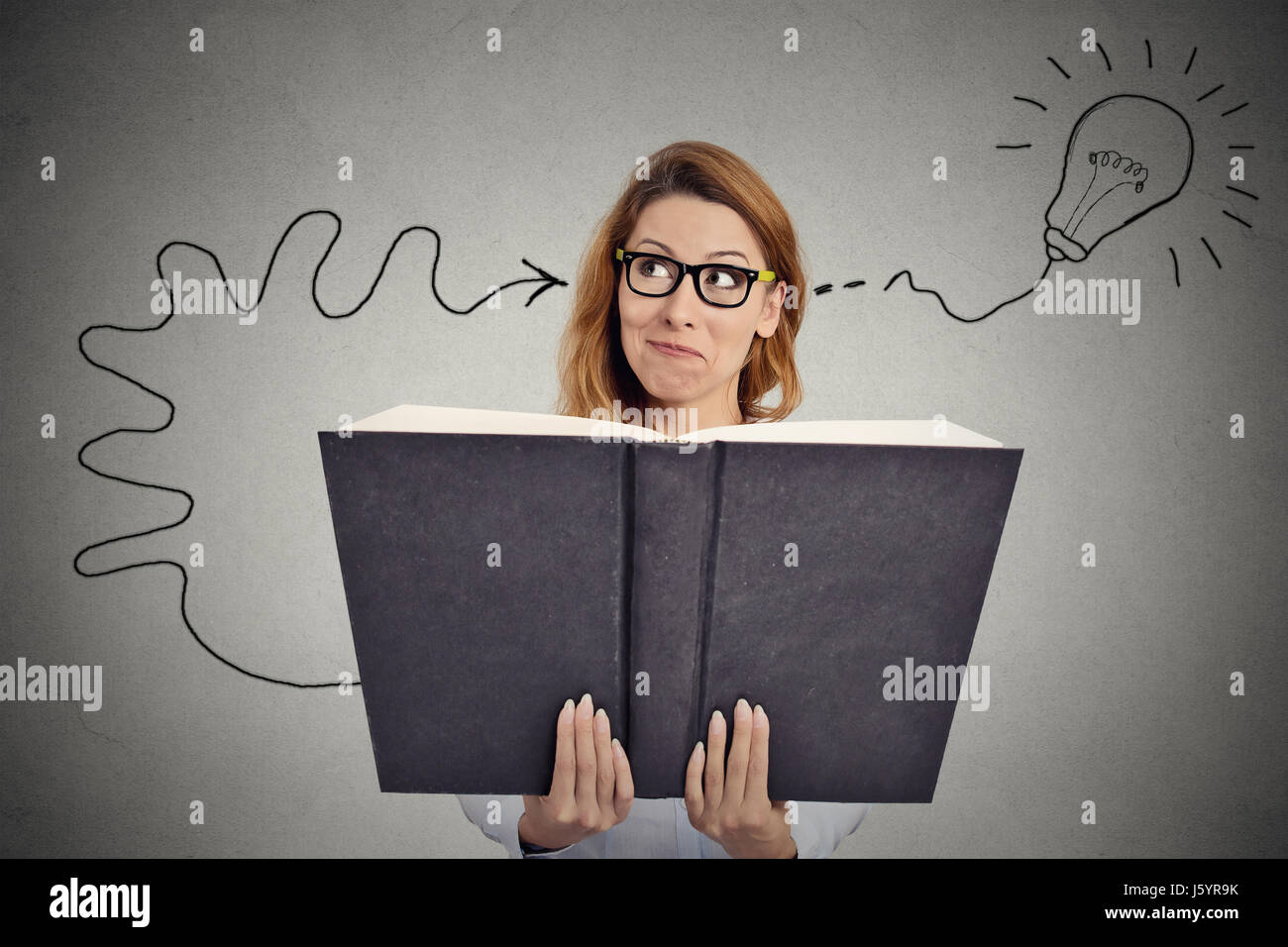 Woman reading a huge book has a good idea Stock Photo - Alamy