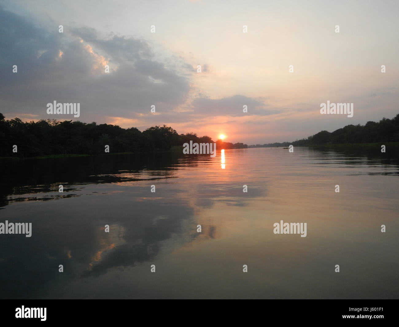 This image depicts a serene sunset over the riverside districts of ...