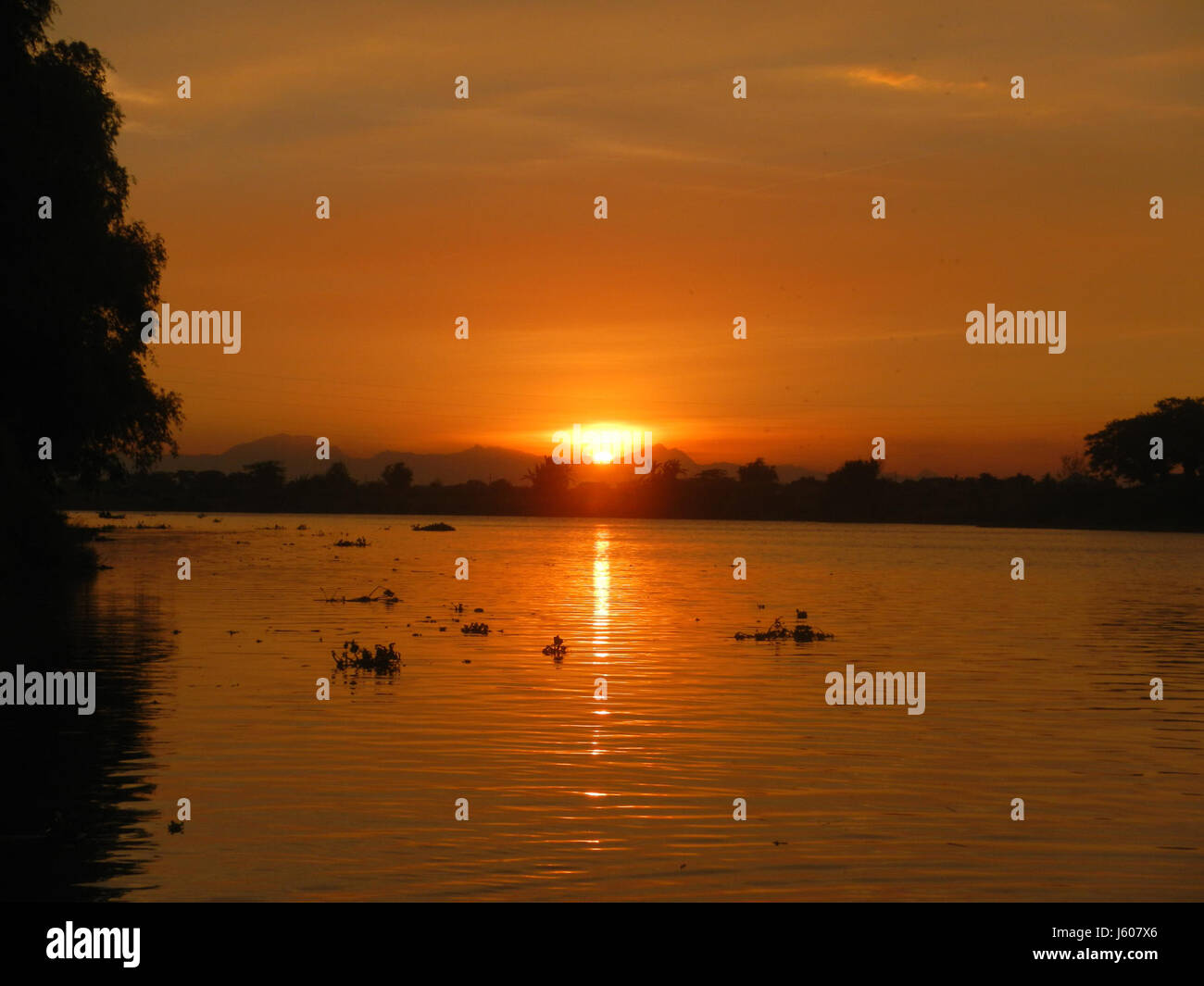 The image captures the serene beauty of sunsets over the Pampanga River ...
