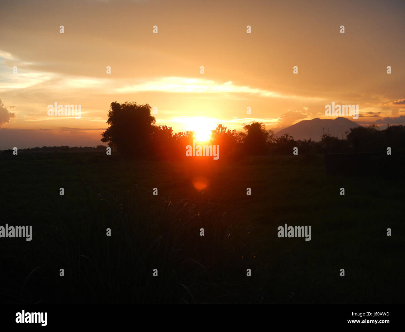 A scenic photograph of a sunset over Mount Arayat, located in the towns ...