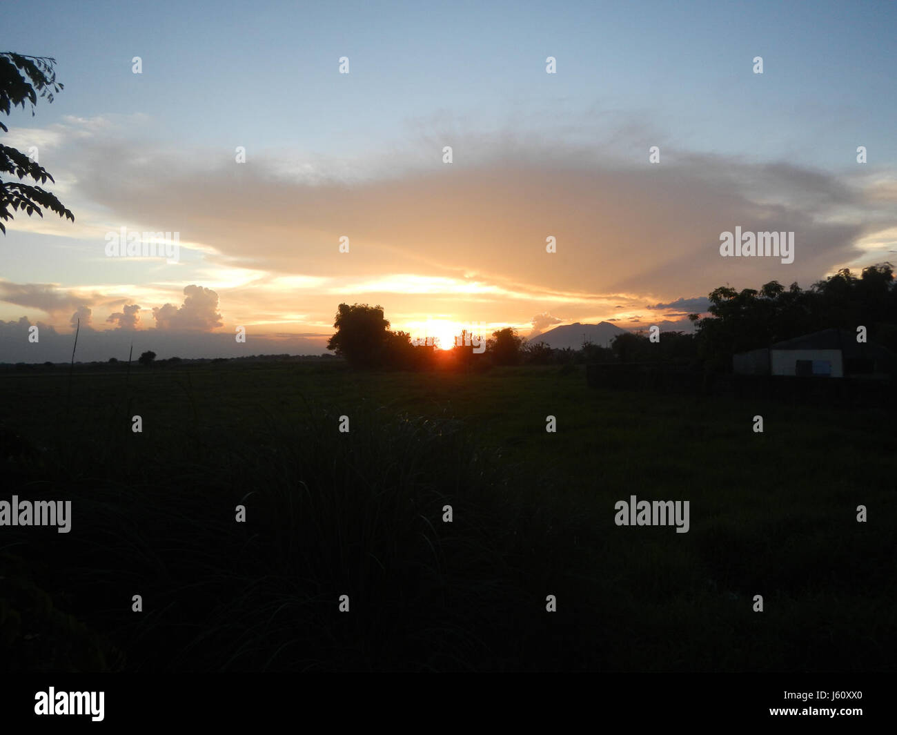 This photograph captures a sunset view of Mount Arayat, located in ...