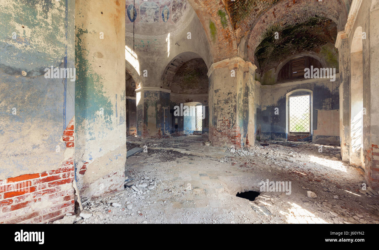 Inside an abandoned looted temple. Columns and a dome with crumbling ...