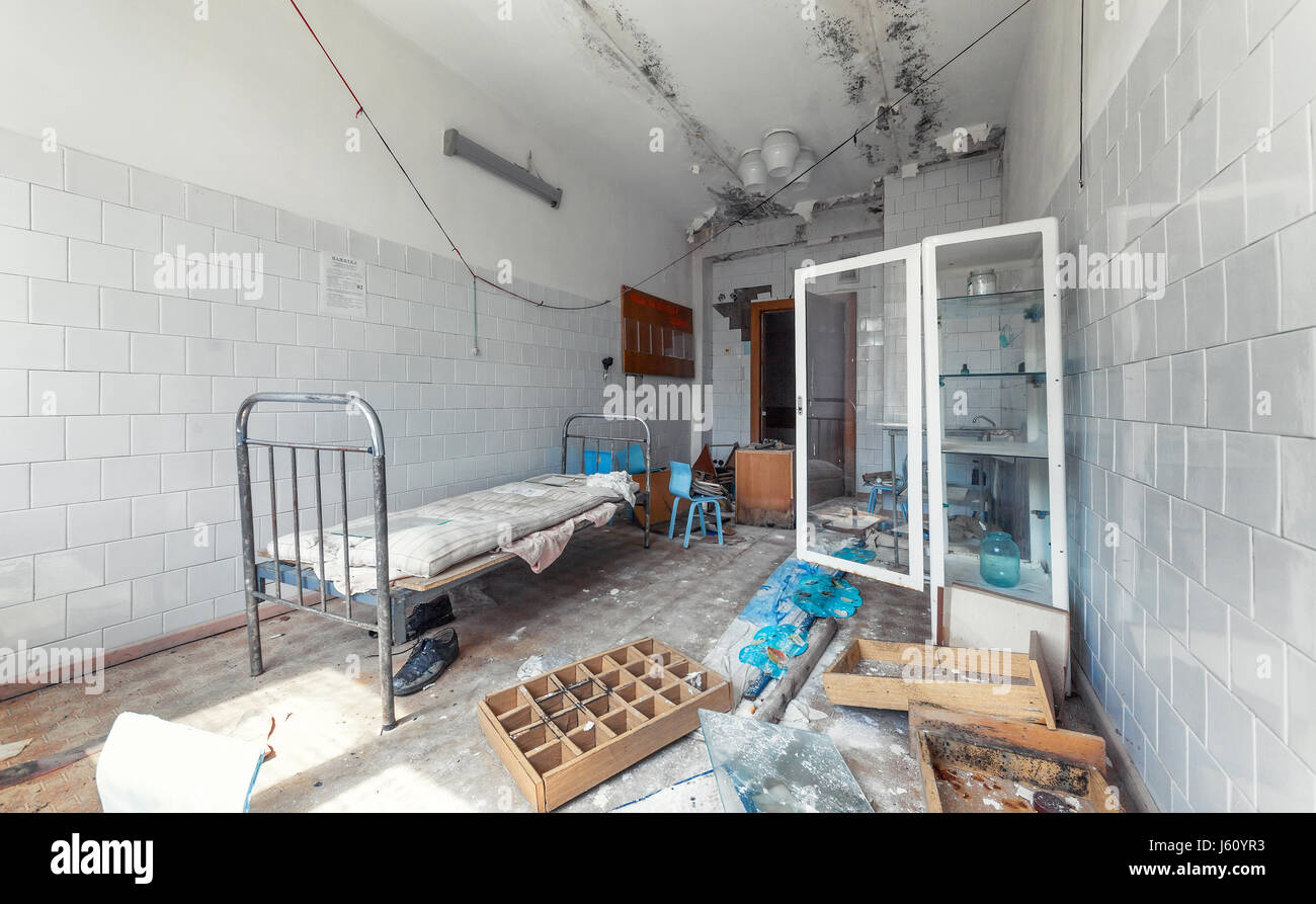 Abandoned and destroyed medical room with a medical bed Stock Photo - Alamy