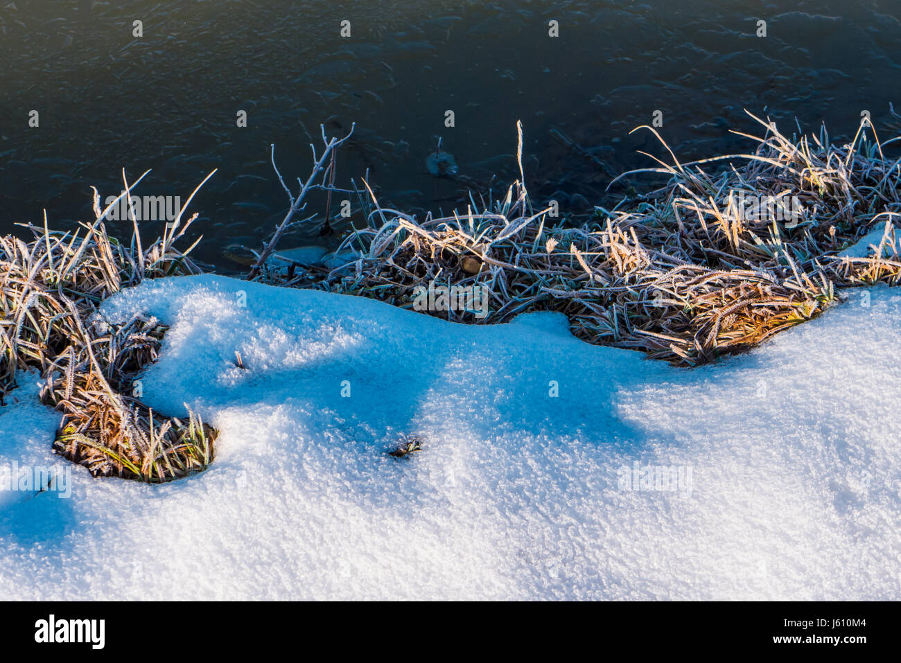 Frozen water, snow and frost by the lake Stock Photo - Alamy