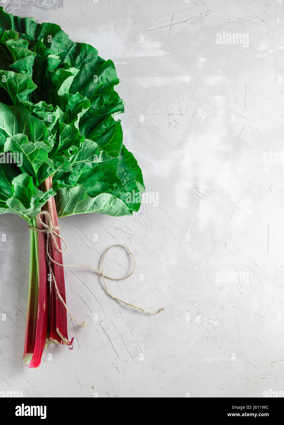 Fresh organic rhubarb stems with leaves on grey concrete stone ...