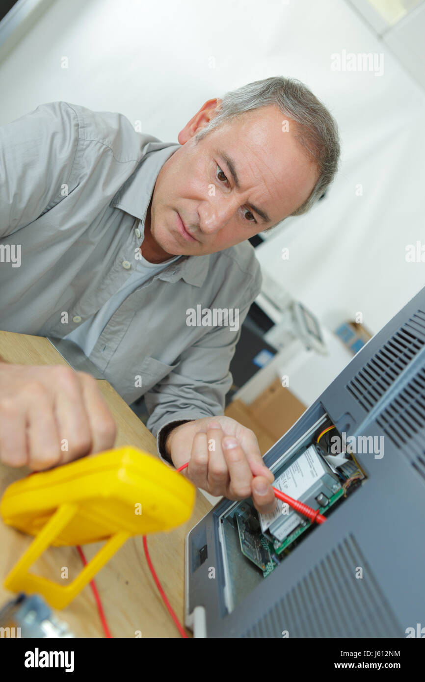 Senior technician using multi meter to test electrical appliance Stock ...