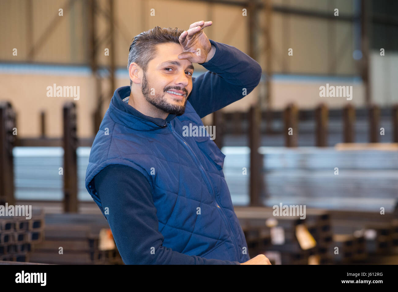 factory worker wiping sweat from brow Stock Photo - Alamy