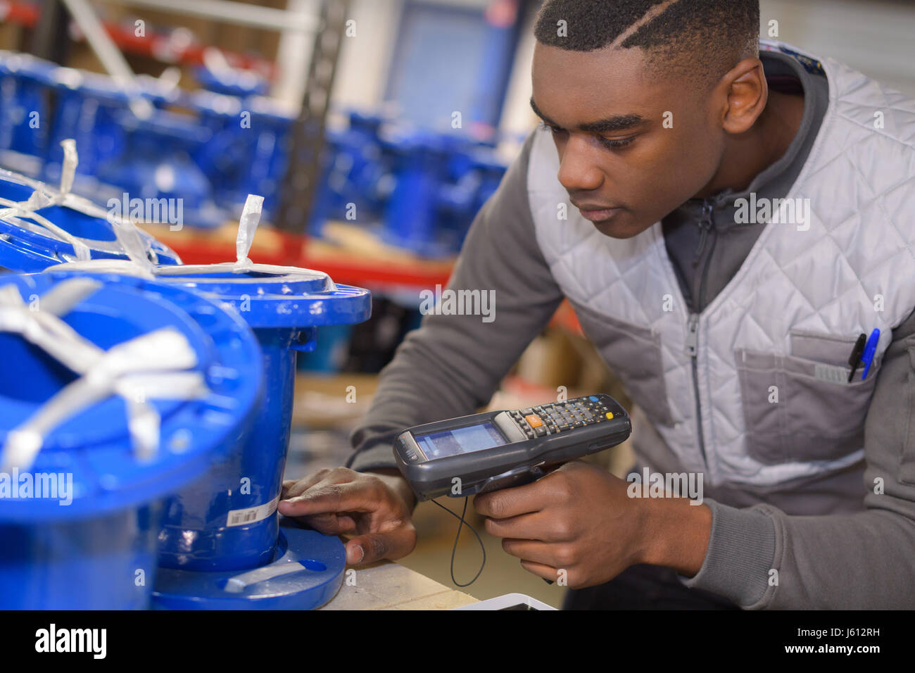 Worker using handheld scanner Stock Photo - Alamy