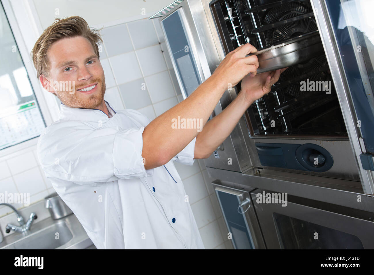 Portrait of chef loading oven Stock Photo - Alamy