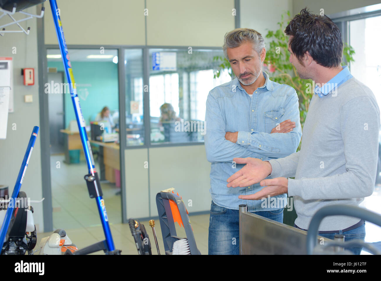Two men looking at equipment Stock Photo - Alamy