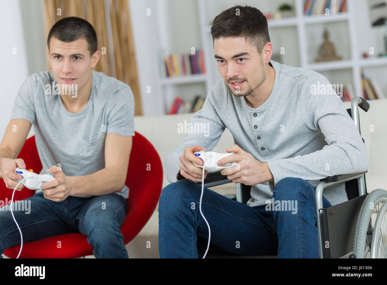 Two men playing computer game, one in wheelchair Stock Photo - Alamy