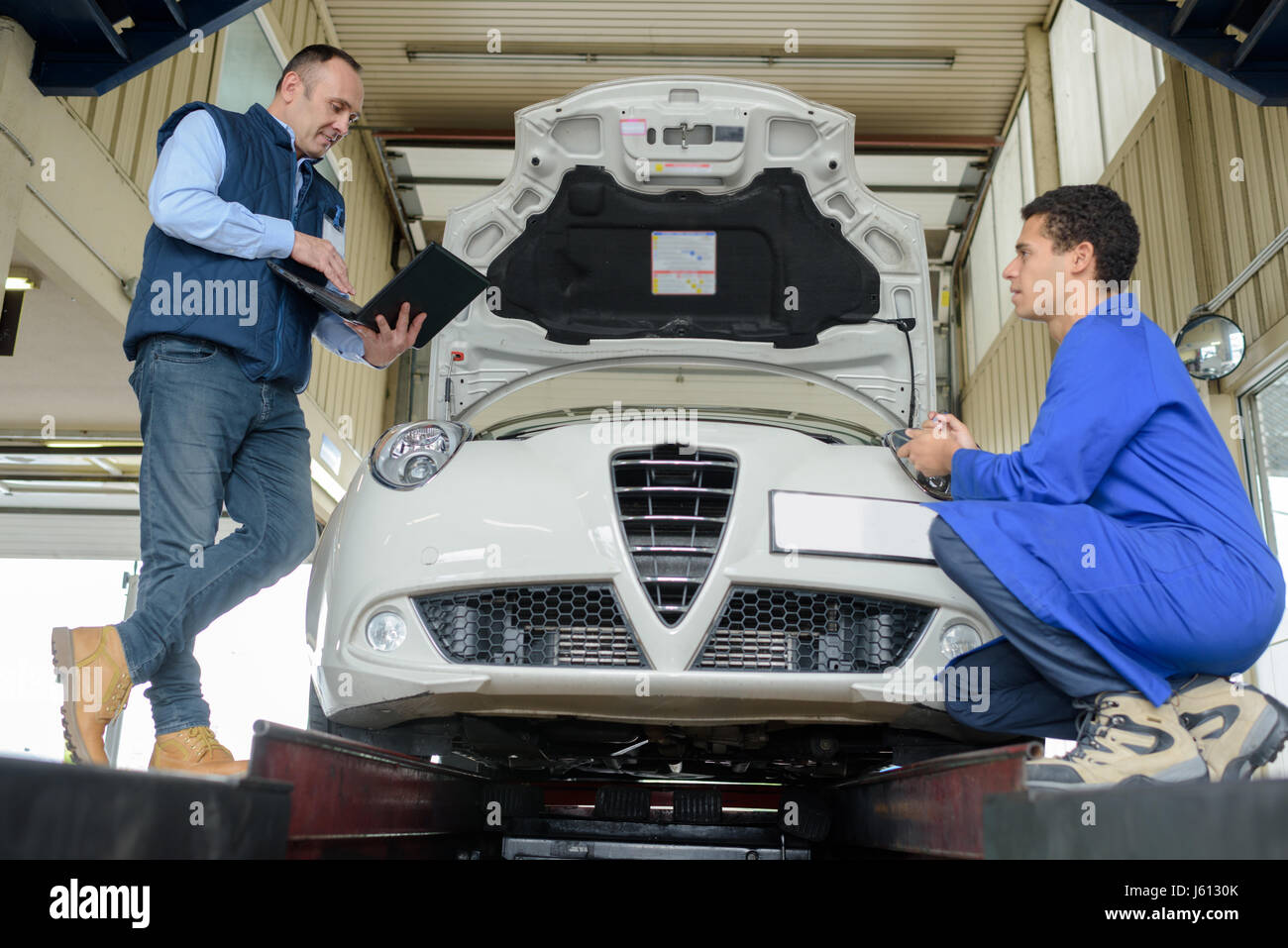 Men inspecting car Stock Photo - Alamy