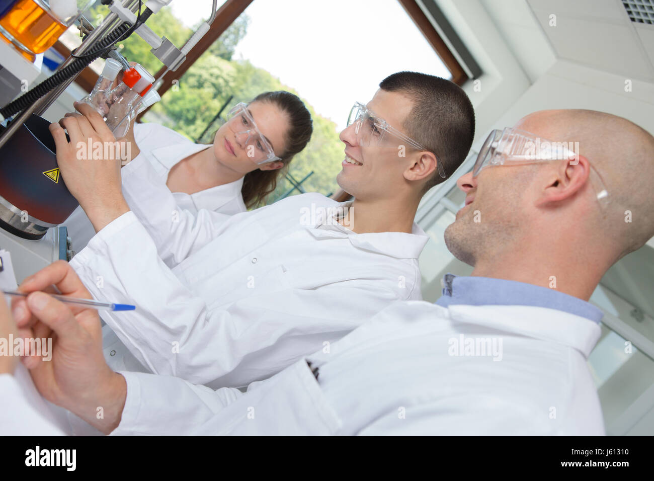 Science students performing experiment Stock Photo - Alamy