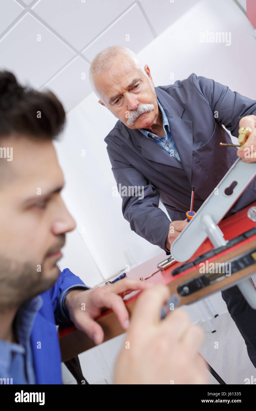 Men fitting new door lock to interior door Stock Photo - Alamy