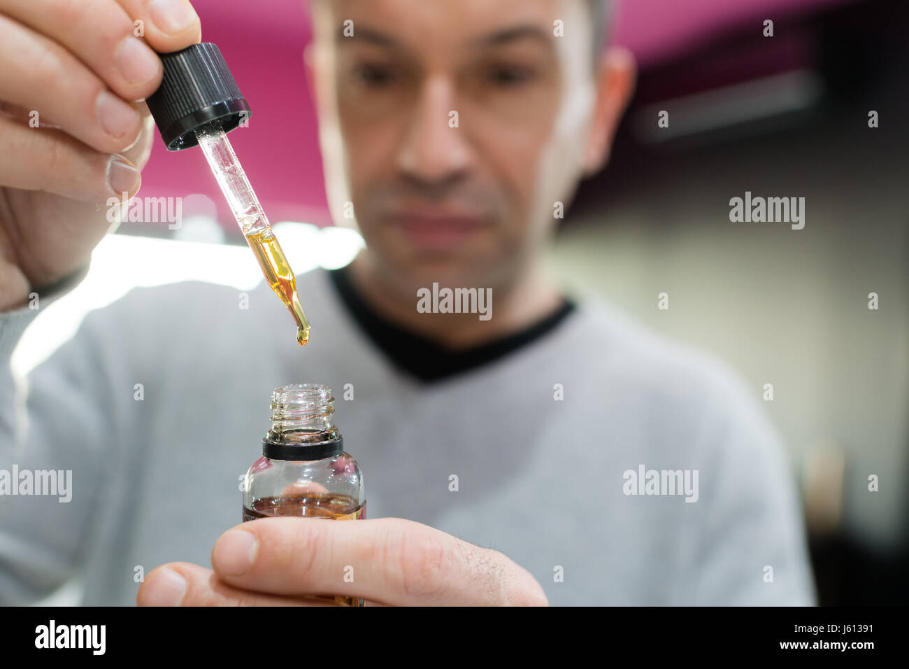 vaping device and e-liquid in the mans hand Stock Photo - Alamy