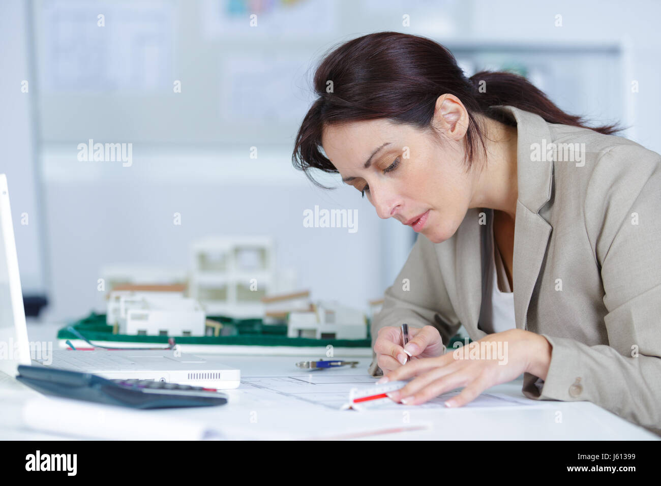 Female architect using scale ruler Stock Photo - Alamy