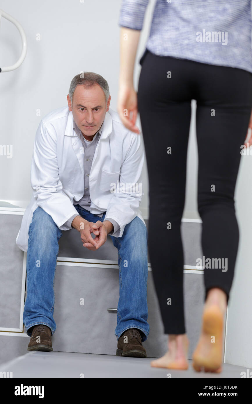 Podiatrist watching patient walk Stock Photo - Alamy