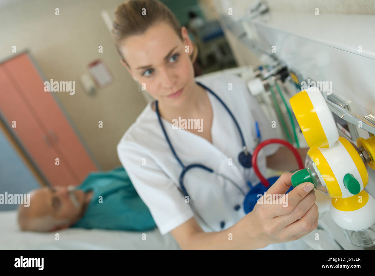 Nurse adjusting equipment in patient's room Stock Photo - Alamy