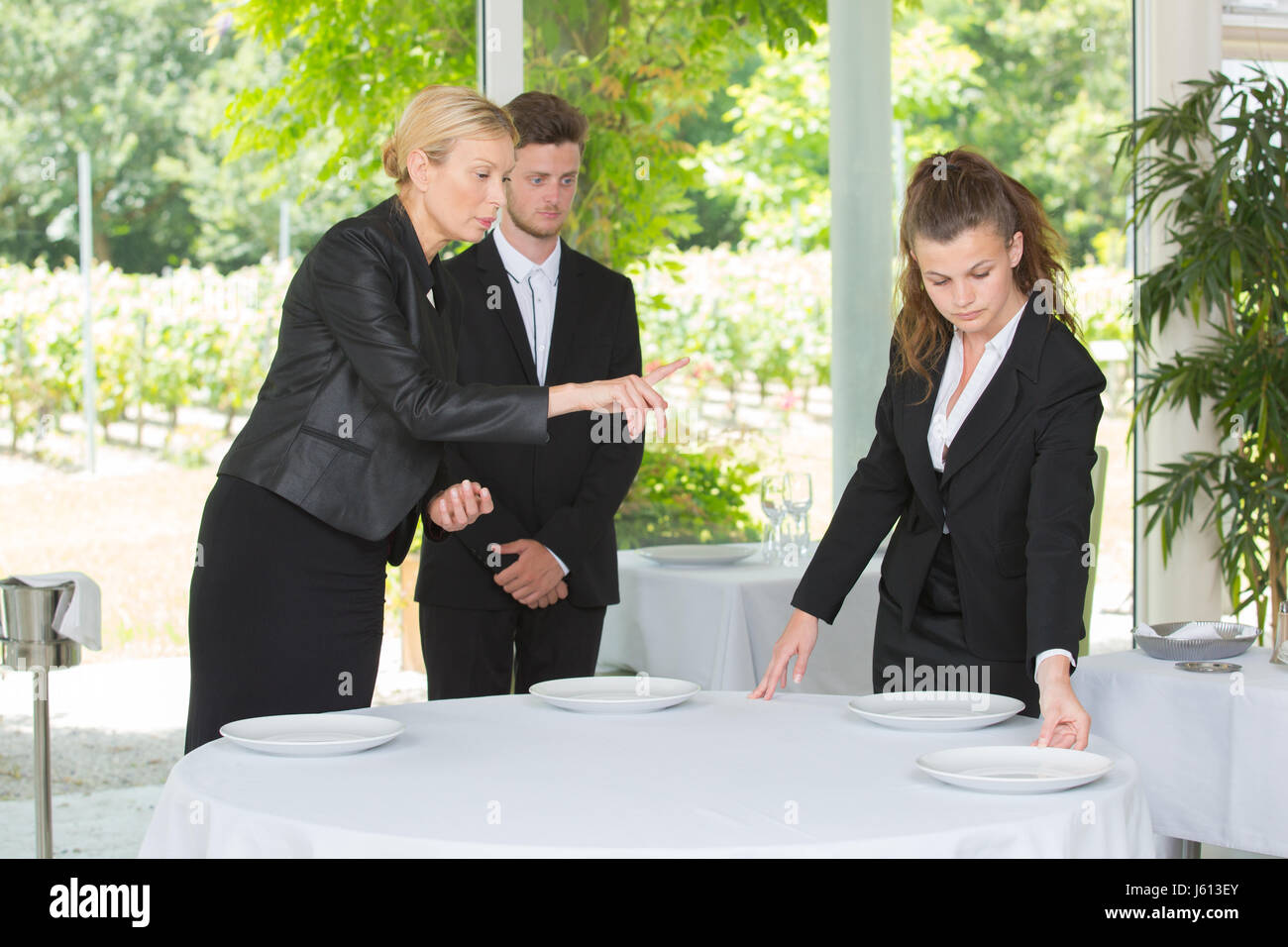 Waitress learning how to set table Stock Photo - Alamy