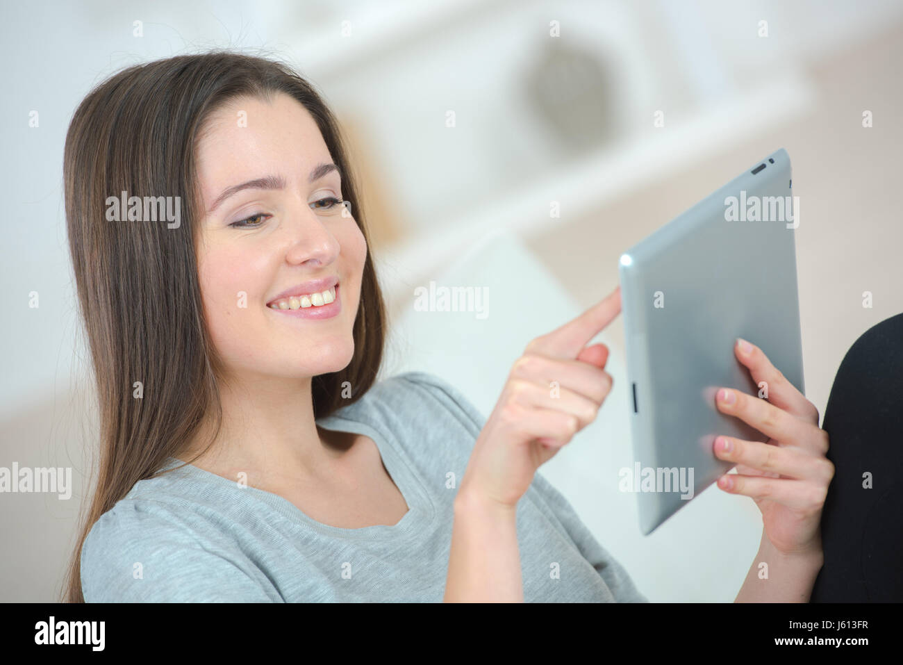 Teen girl using tablet sitting hi-res stock photography and images - Alamy