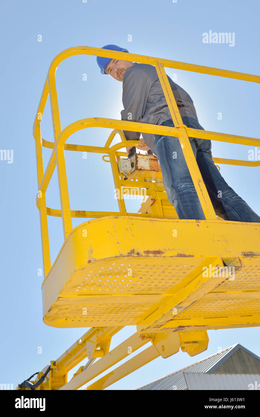 Upward view of man in cherry picker bucket Stock Photo - Alamy