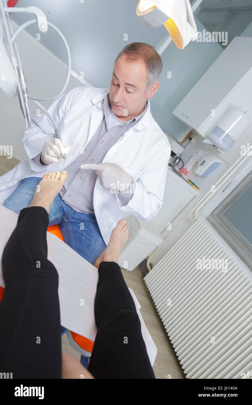 Podiatrist pointing to patient's toes Stock Photo - Alamy