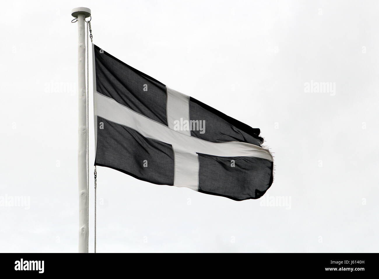 Cornish independence flag flying against a white sky Stock Photo - Alamy