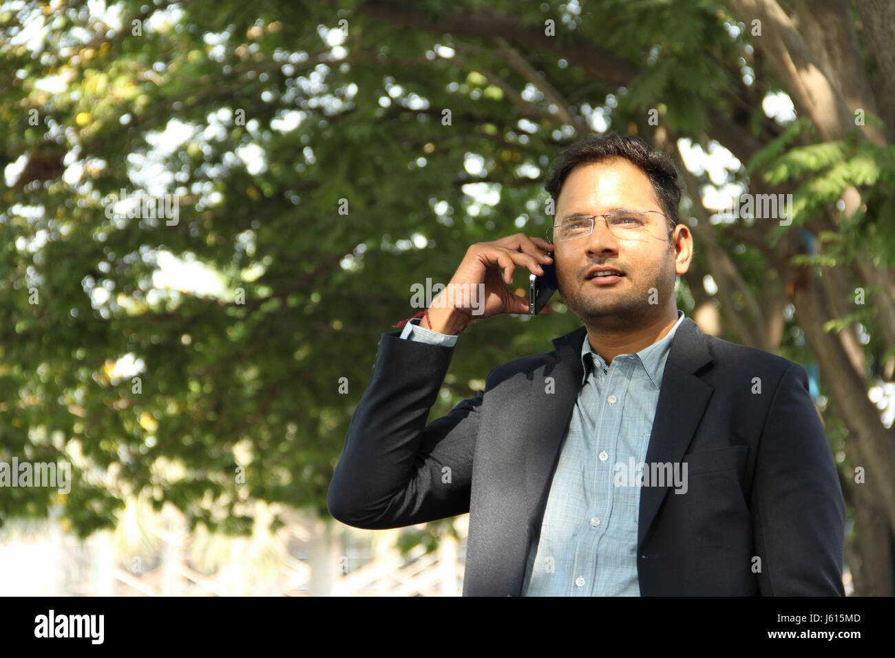 Confident young Indian man in suit talking on his mobile Stock Photo ...