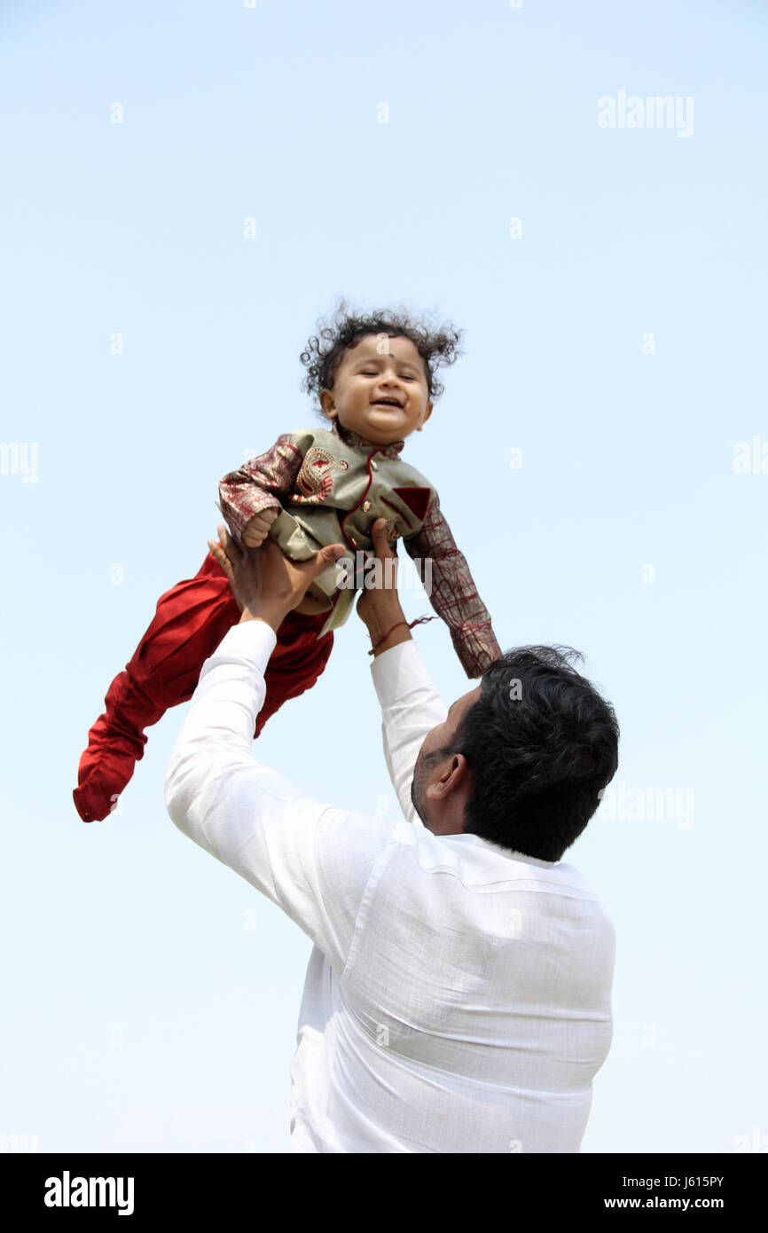Young Indian father playing with toddler by throwing, tossing him up in ...