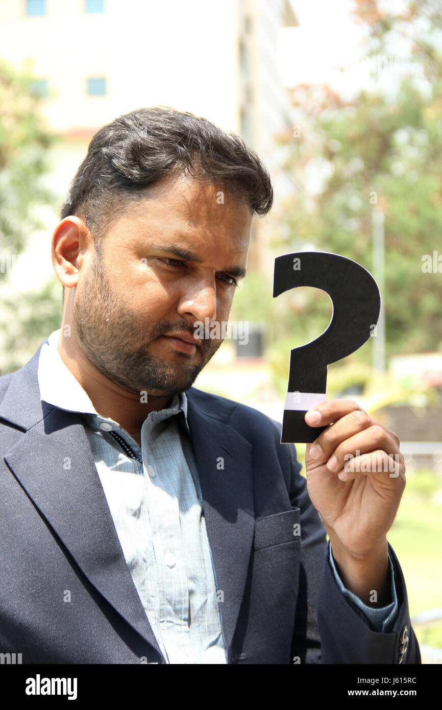 Young Indian corporate man looking at question mark Stock Photo - Alamy
